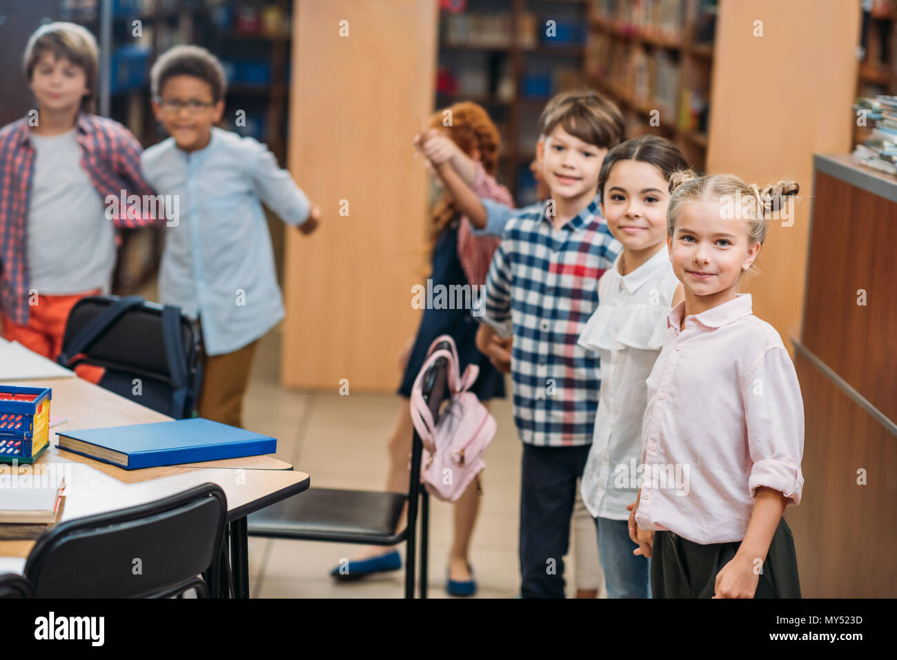 adorable little kids standing in row in library Stock Photo - Alamy