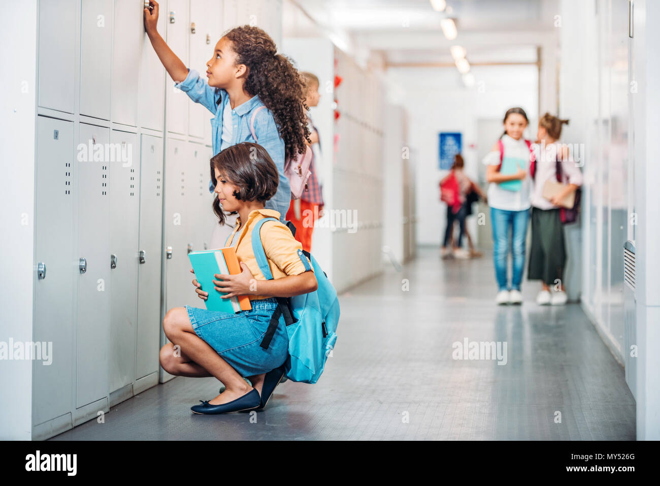 girls opening lockers in school corridor Stock Photo - Alamy