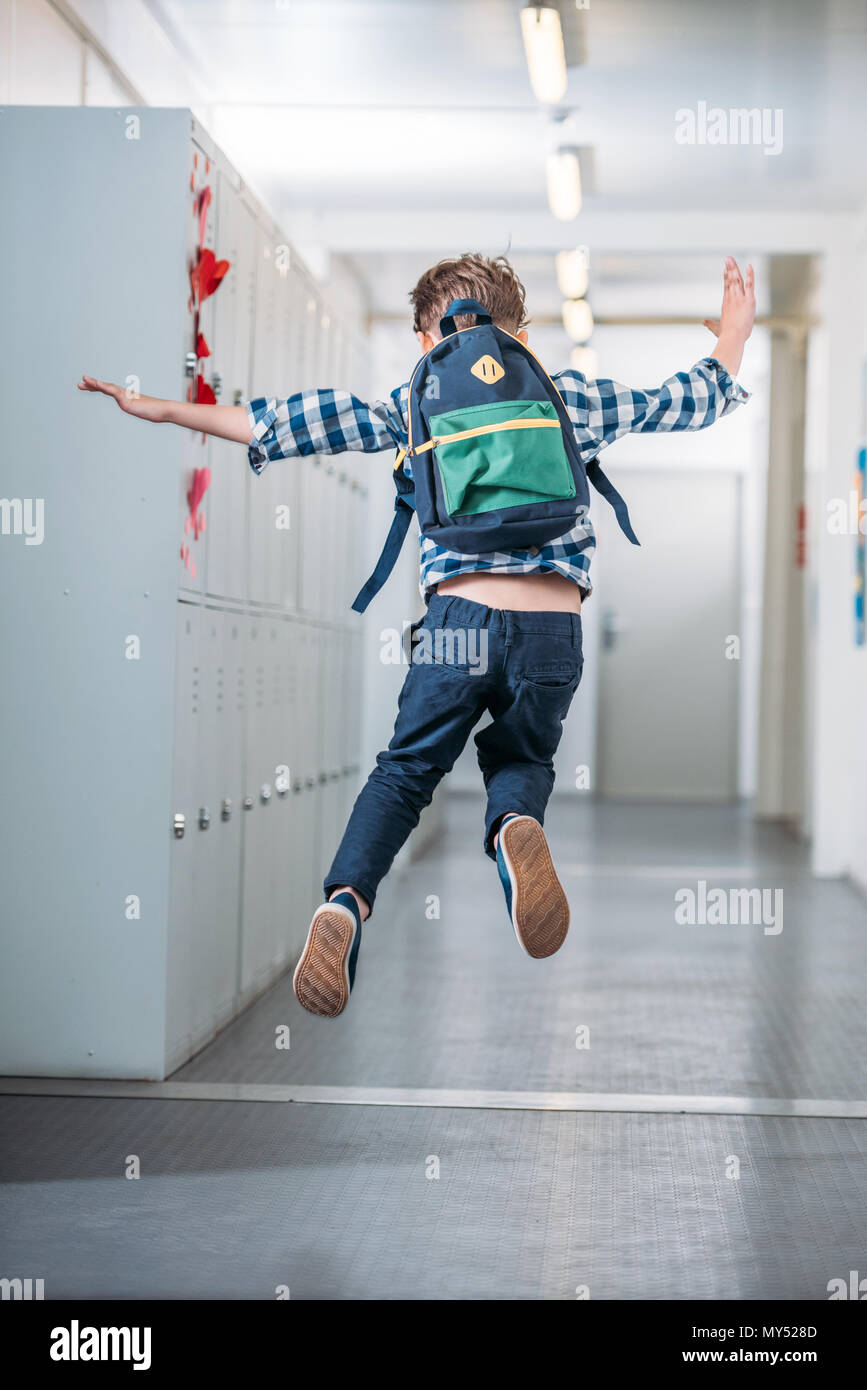 back view of little boy jumping in school corridor Stock Photo - Alamy