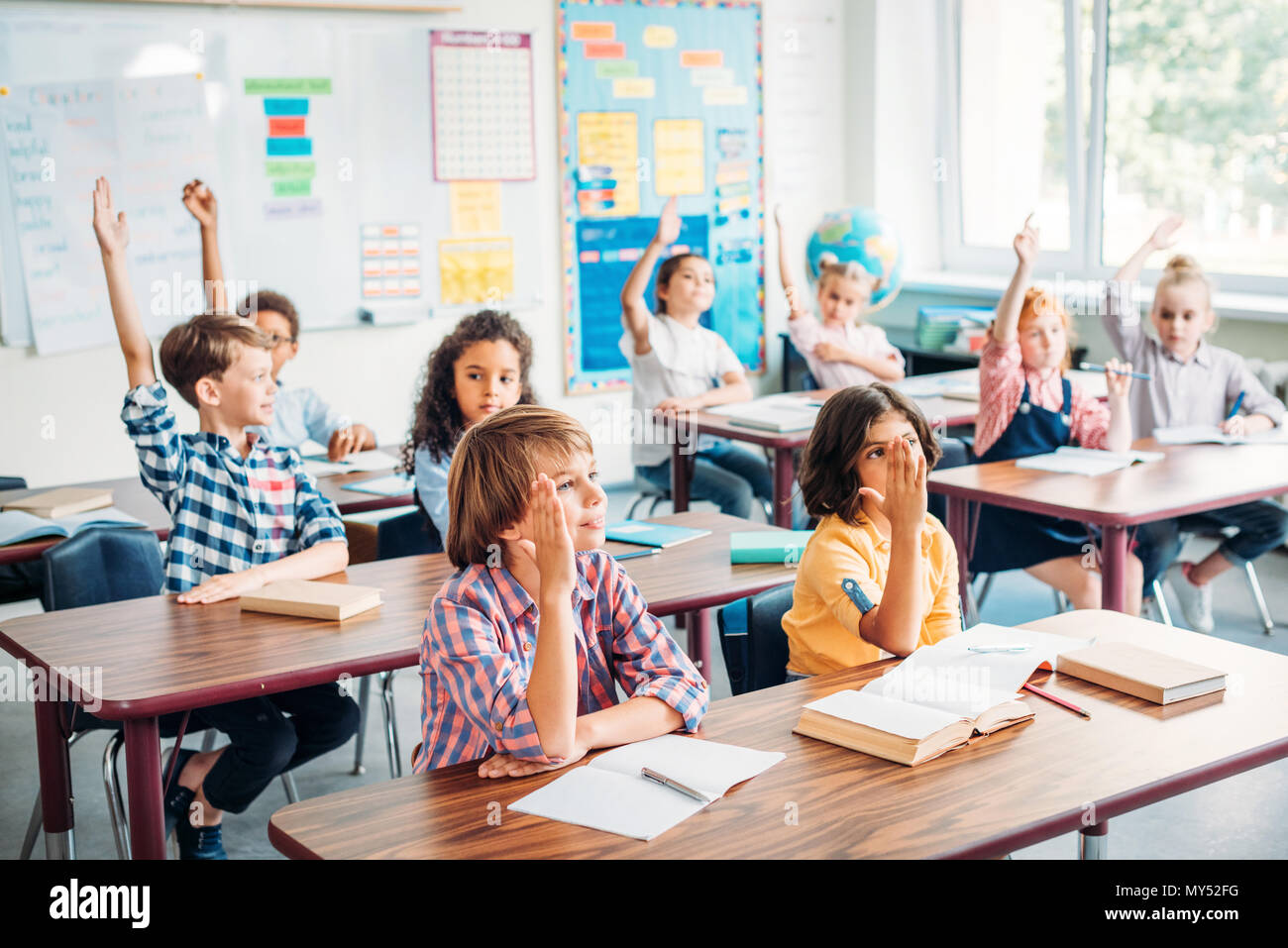 adorable little kids raising hands in class Stock Photo - Alamy