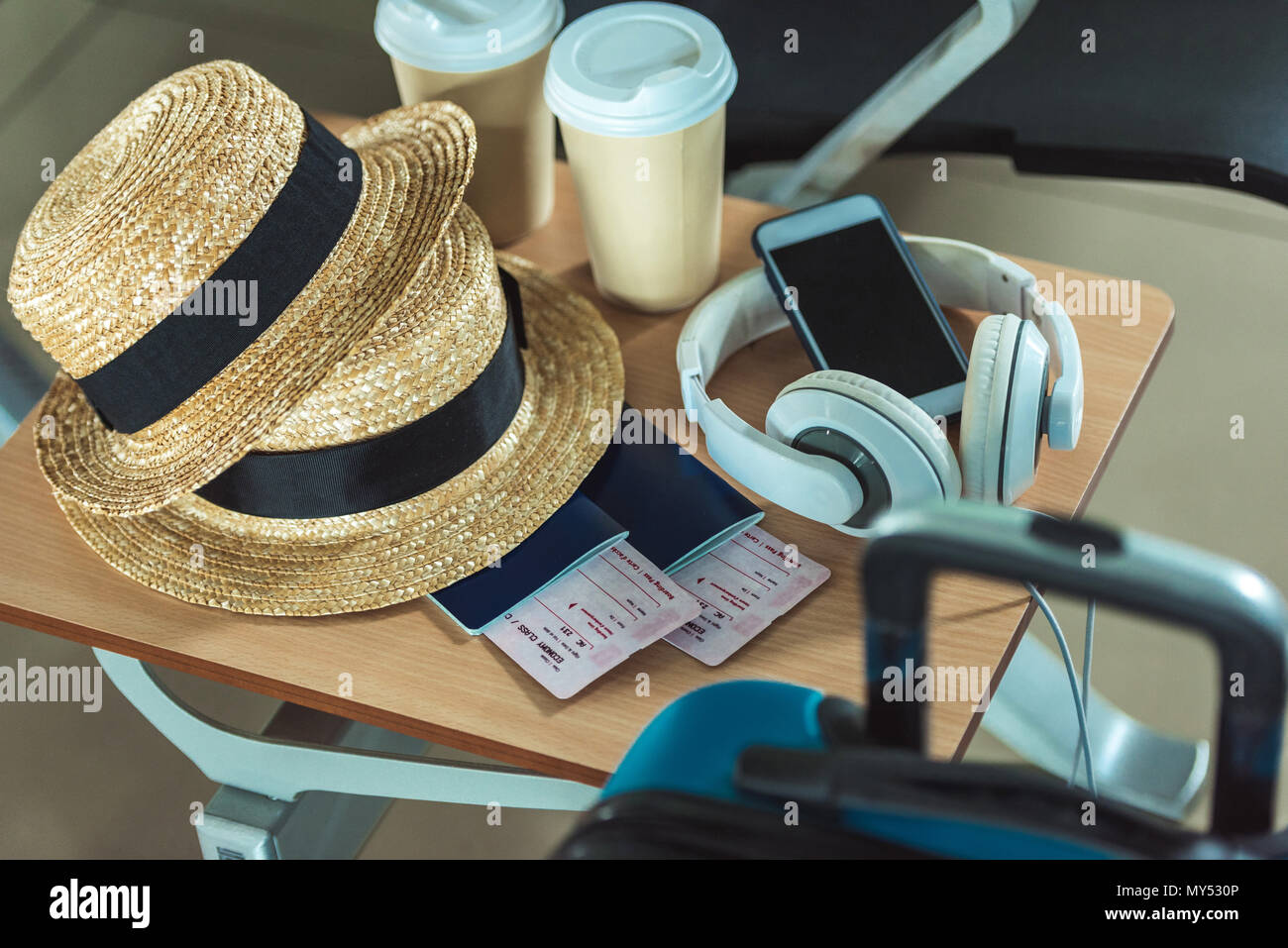 close up view of hats, smartphone, headphones, passports and tickets ...
