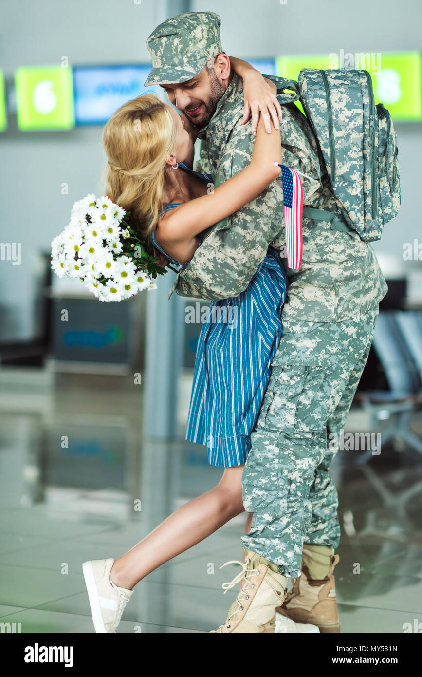wife meeting husband in military uniform in airport Stock Photo - Alamy