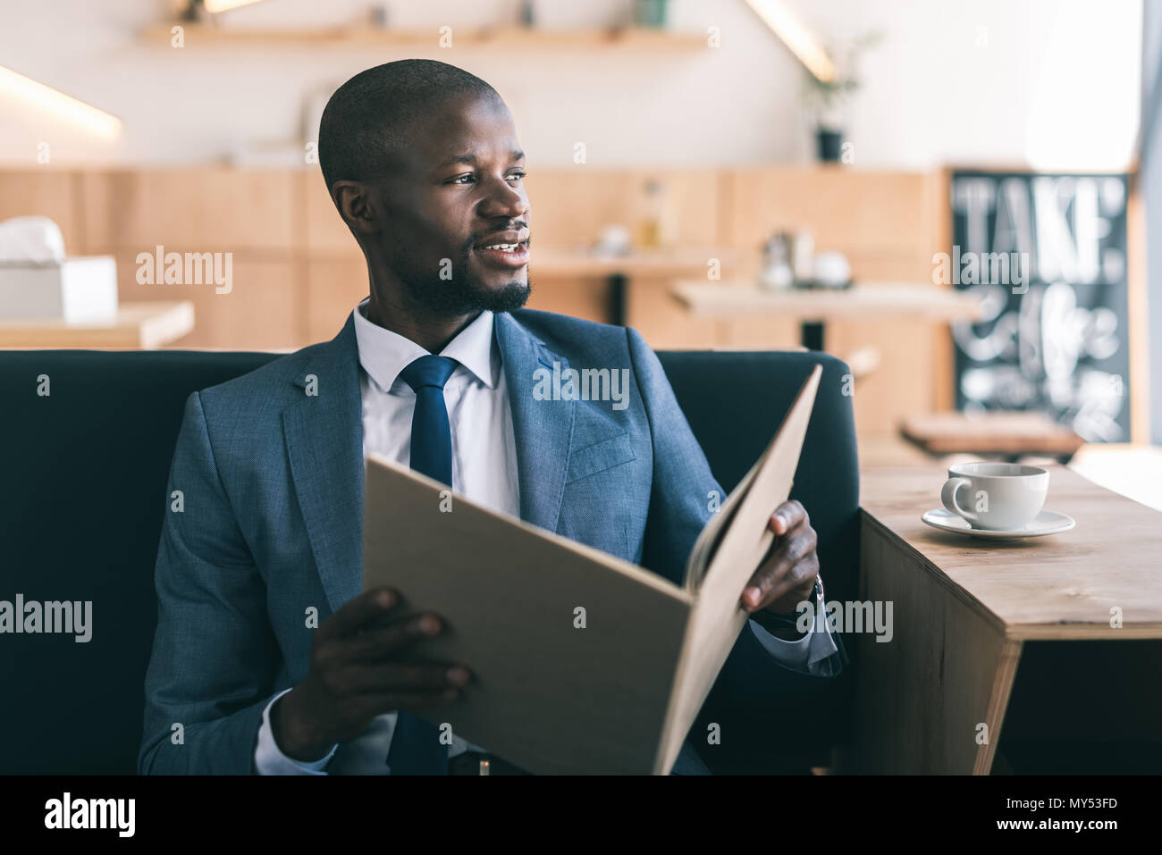 handsome african american businessman with cup of coffee reading menu ...