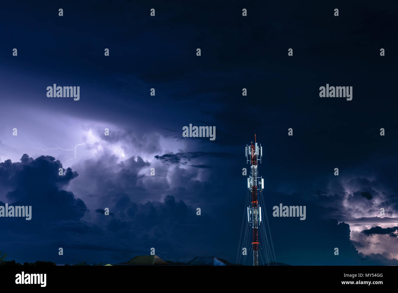 Thunderstorm with lightning over the cell phone antenna tower at night ...