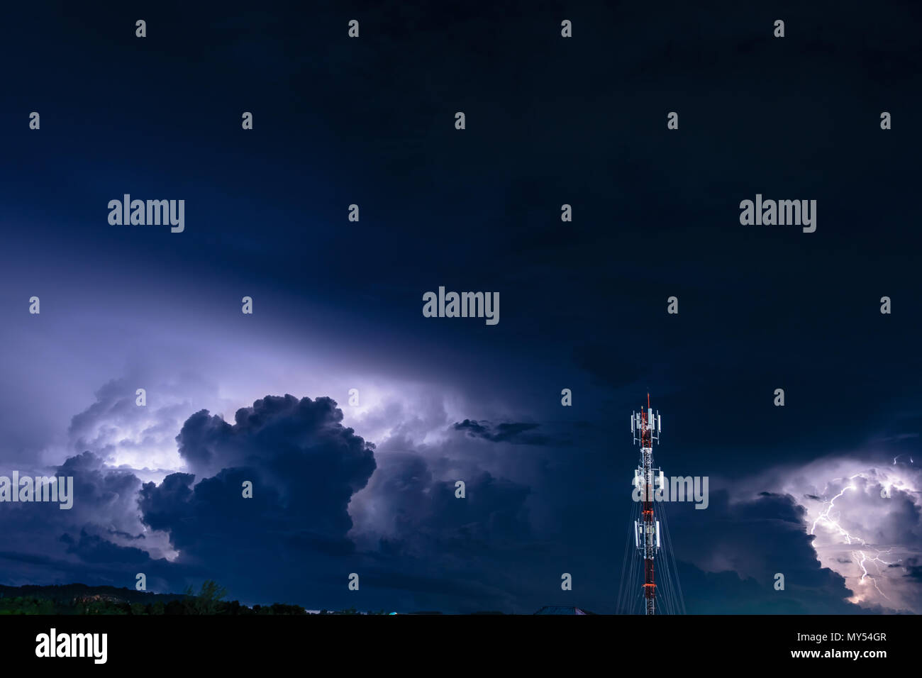 Thunderstorm with lightning over the cell phone antenna tower at night ...