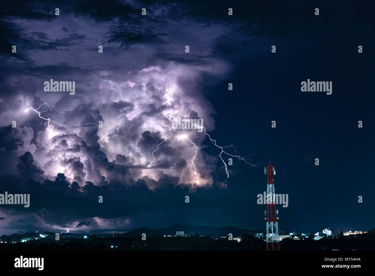 Thunderstorm with lightning over the cell phone antenna tower at night ...
