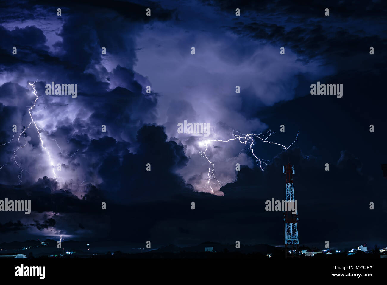 Thunderstorm with lightning over the cell phone antenna tower at night ...
