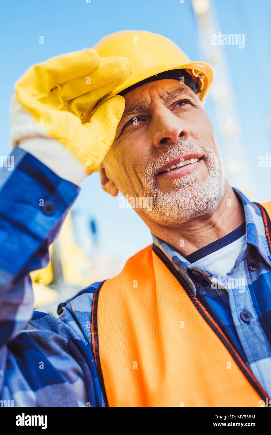 Worker in reflective vest and hardhat at construction site Stock Photo ...