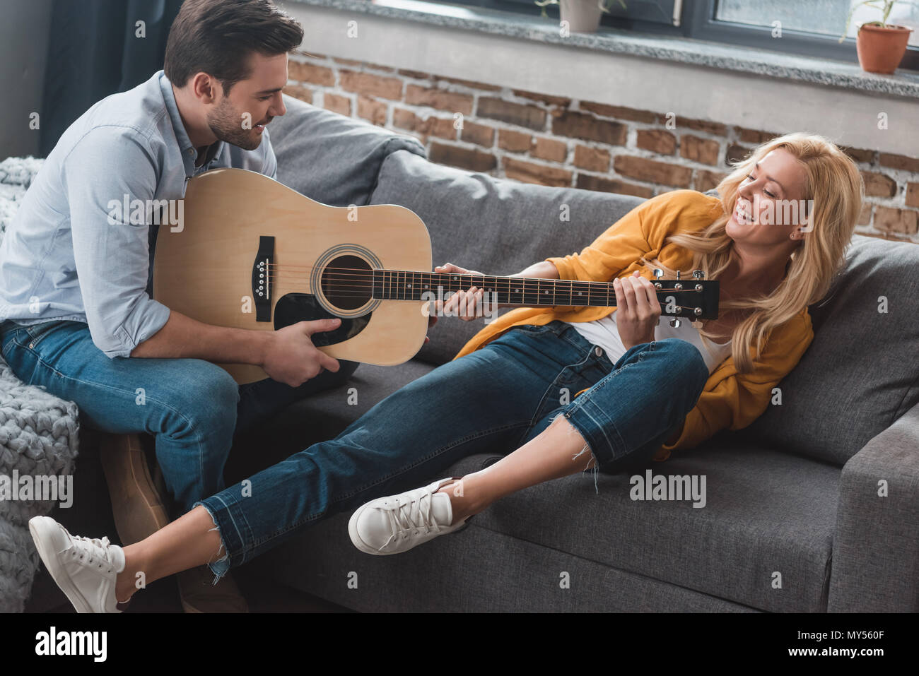 happy young couple having fun while fighting for guitar Stock Photo - Alamy