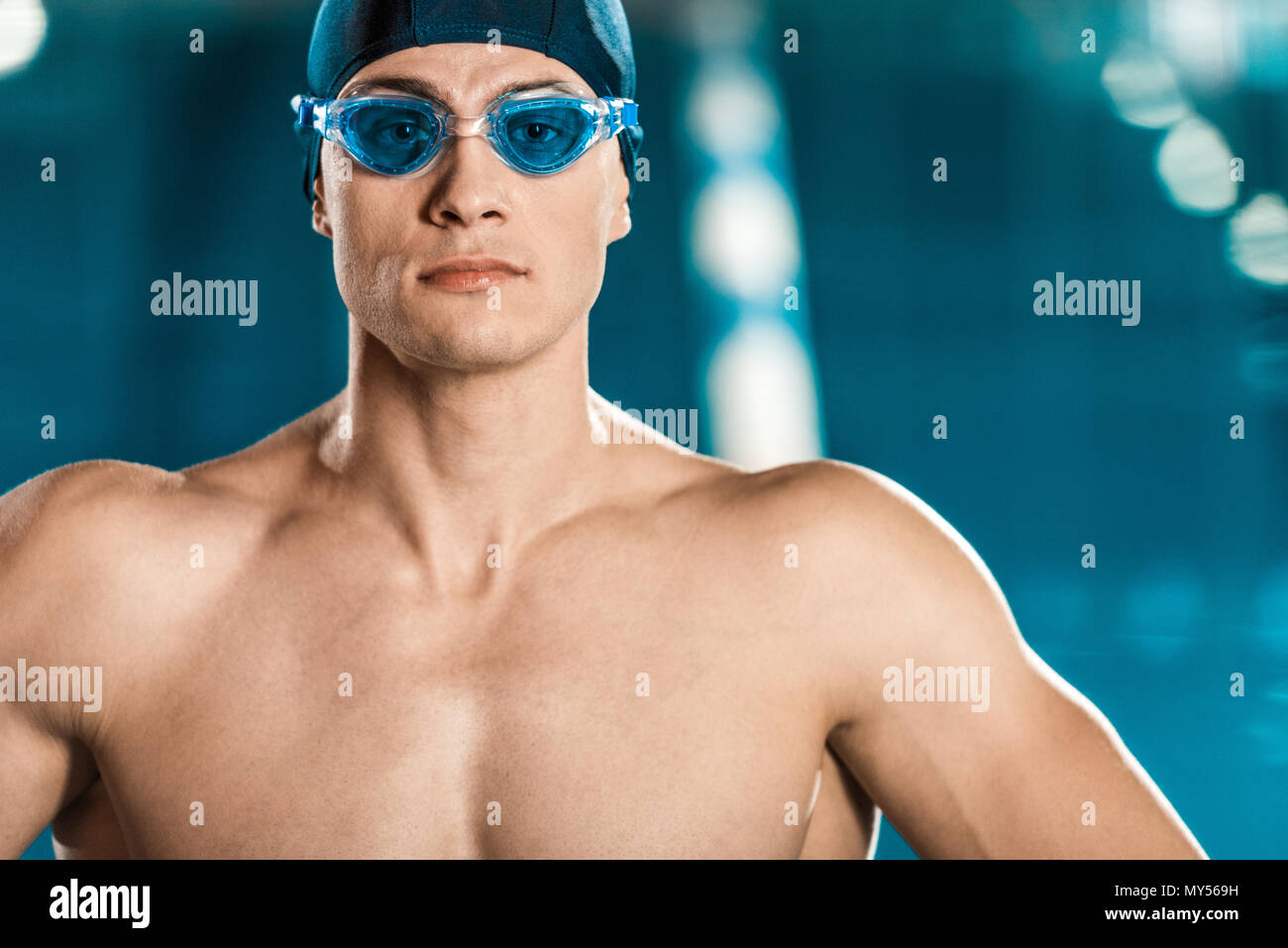 portrait of handsome muscular swimmer in swimming cap and goggles ...