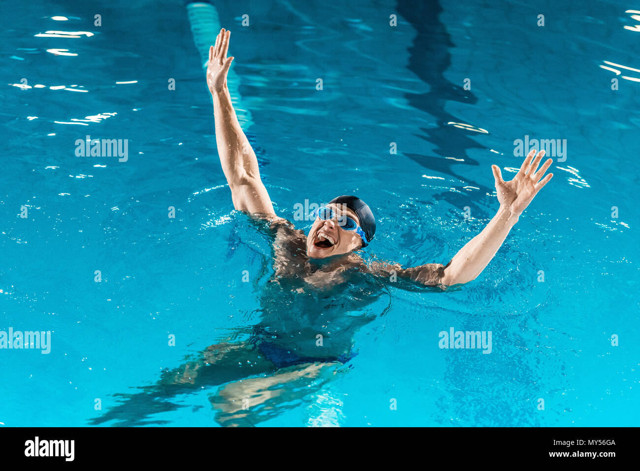excited swimmer in goggles gesturing in competition swimming pool Stock ...