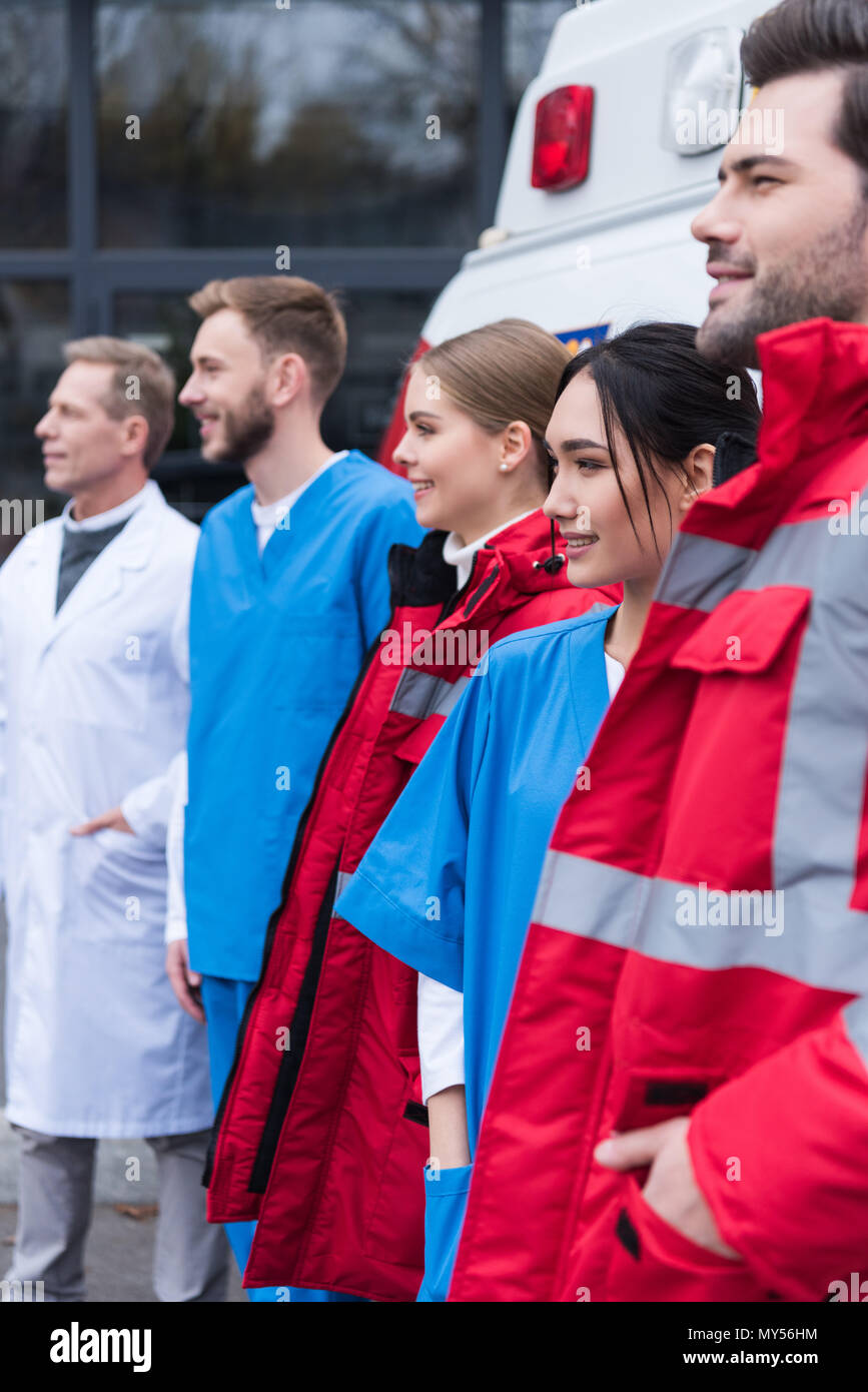 side view of paramedics working team standing in front of car Stock ...