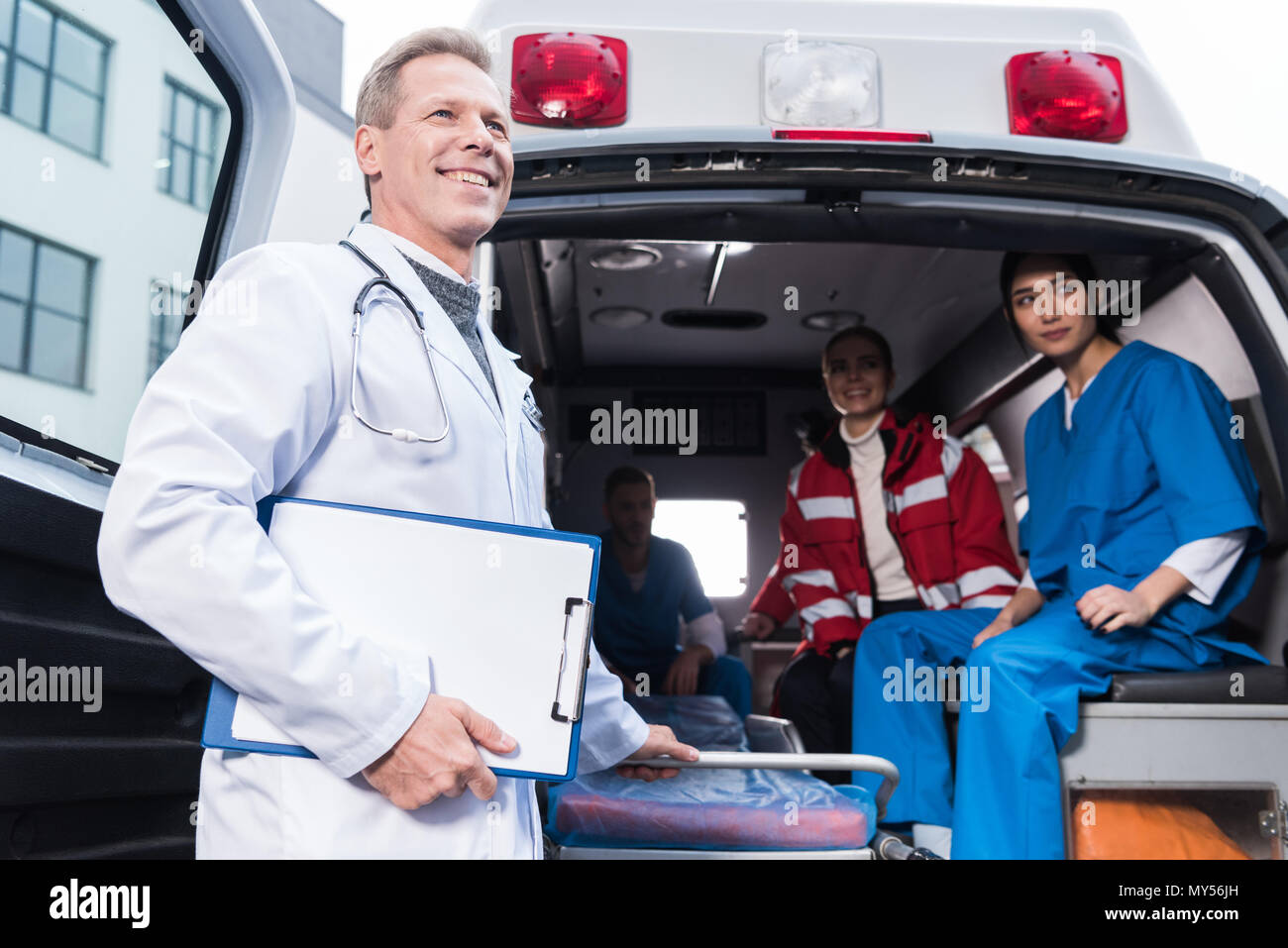 smiling paramedics working team with ambulance Stock Photo - Alamy