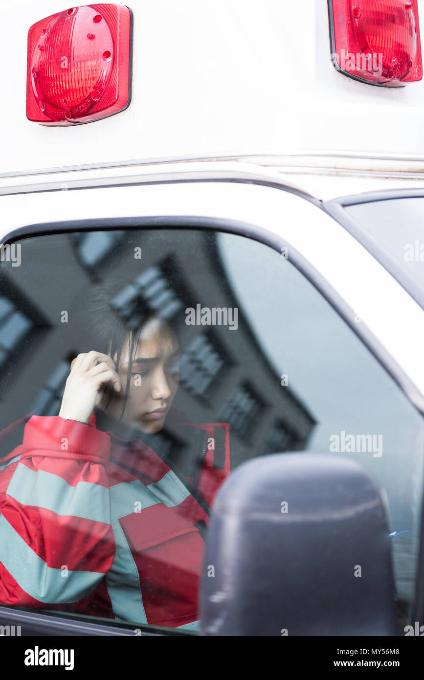 young female Asian paramedic reading something in ambulance Stock Photo ...