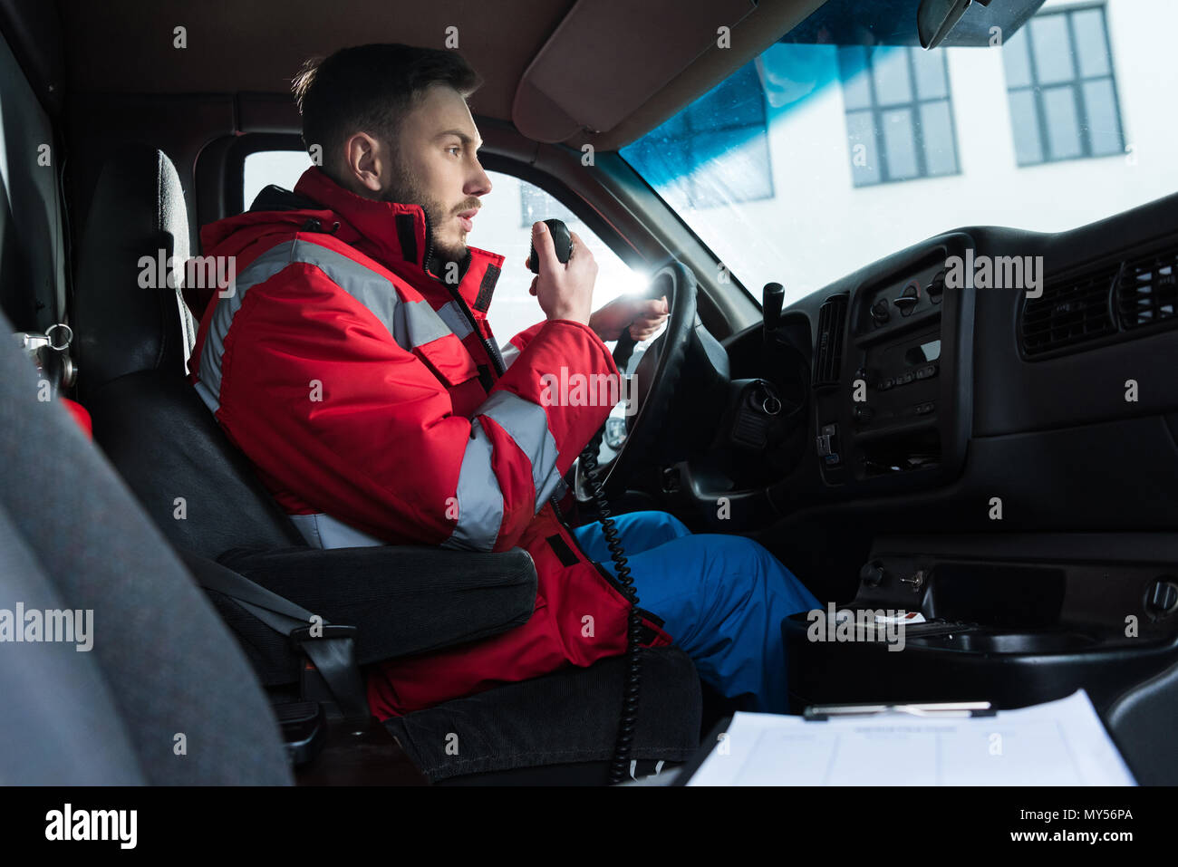 young handsome male paramedic talking by portable radio Stock Photo - Alamy