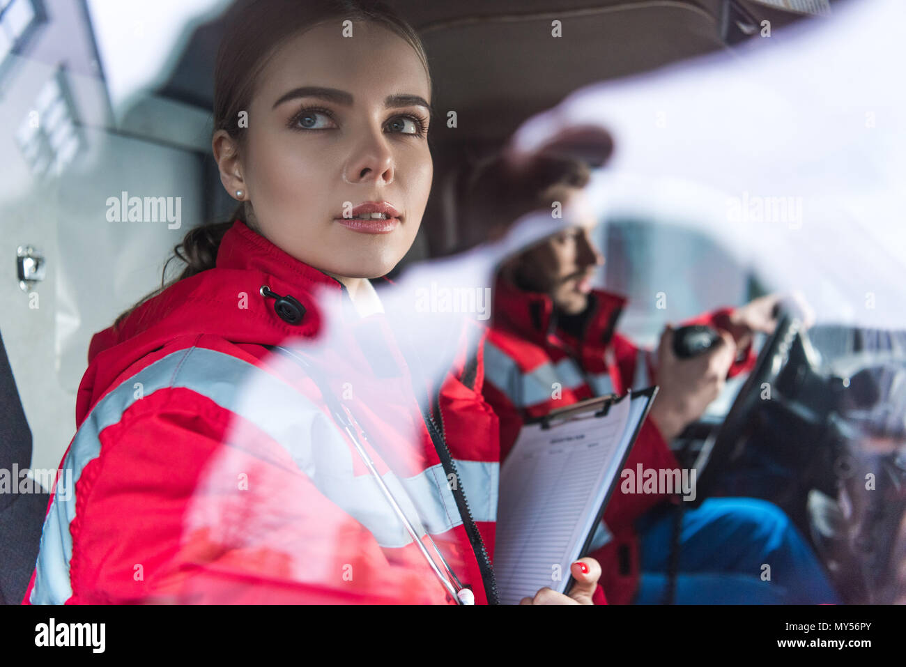 attractive young paramedic sitting in ambulance and looking away Stock ...