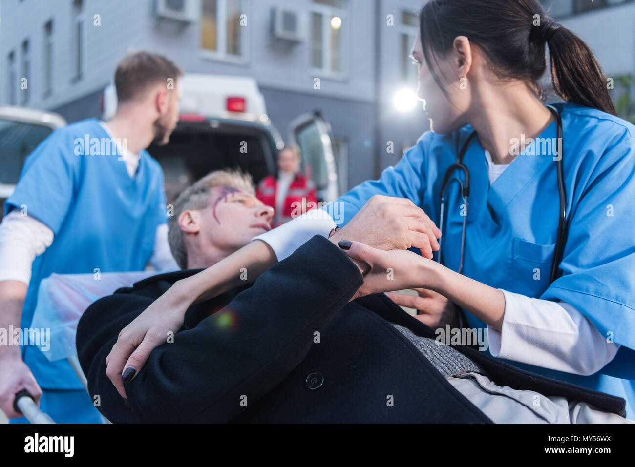 paramedics moving wounded mature man on ambulance stretcher Stock Photo ...