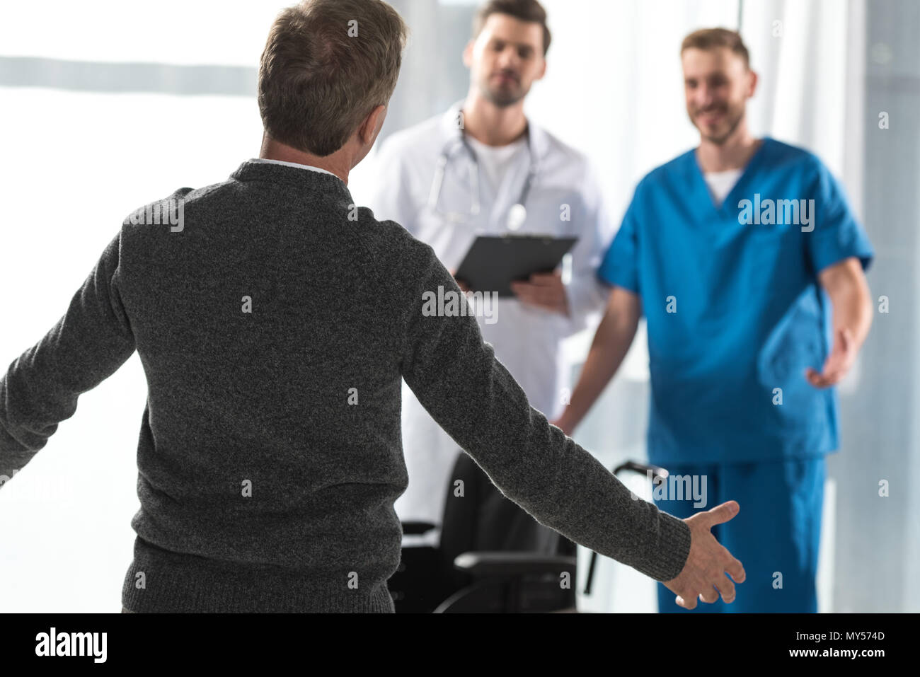 healthy patient going with open arms to smiling doctors Stock Photo - Alamy