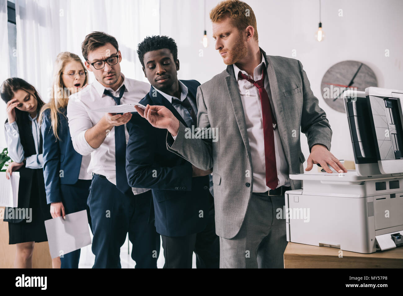 group of businesspeople standing in queue for copier at office Stock ...