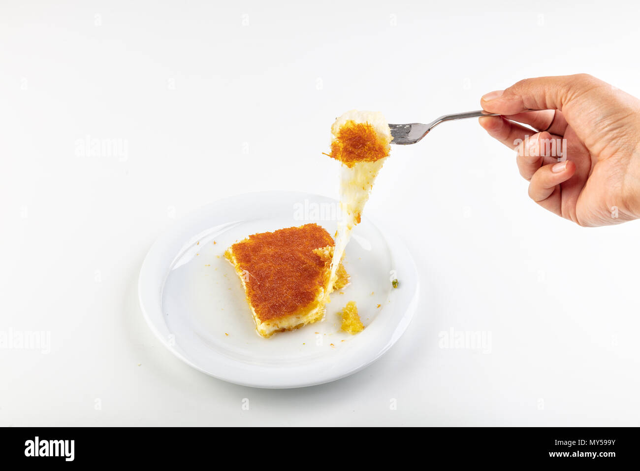 Turkish dessert kunefe on kaymak, cream slide with pistachio powder ...