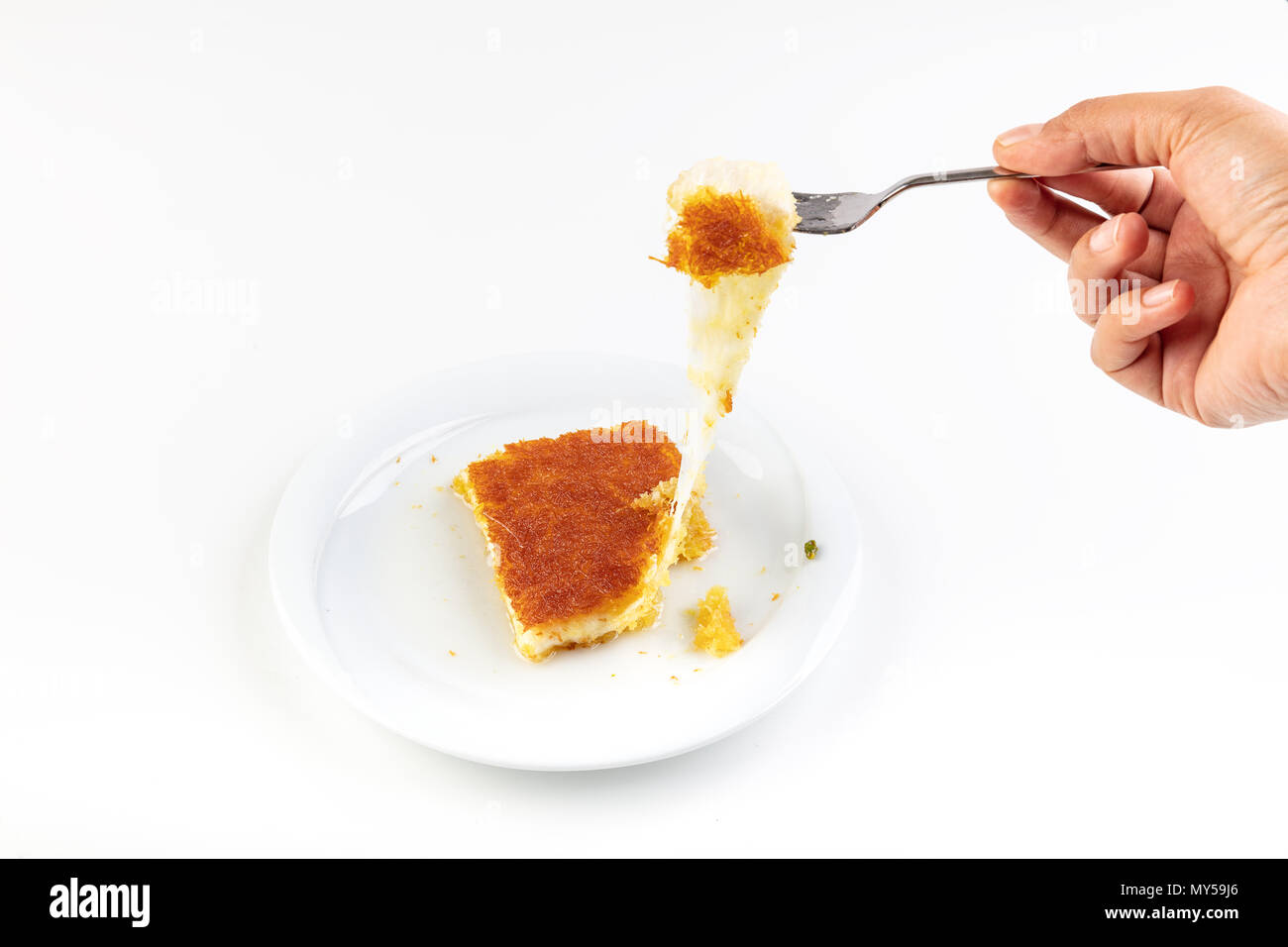 Turkish dessert kunefe on kaymak, cream slide with pistachio powder ...