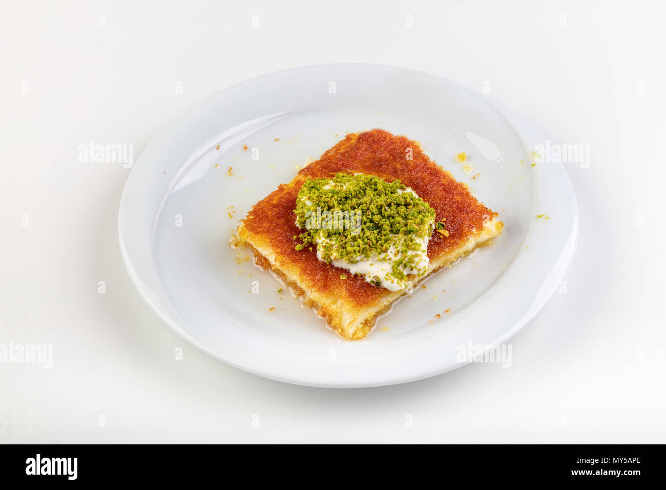 Turkish dessert kunefe on kaymak, cream slide with pistachio powder ...