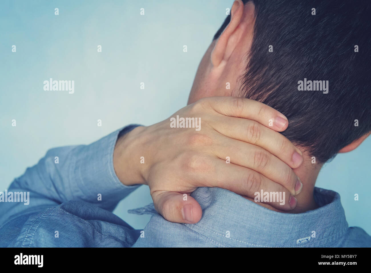 Close up of young man hand on his neck - neck pain concept. a fracture ...
