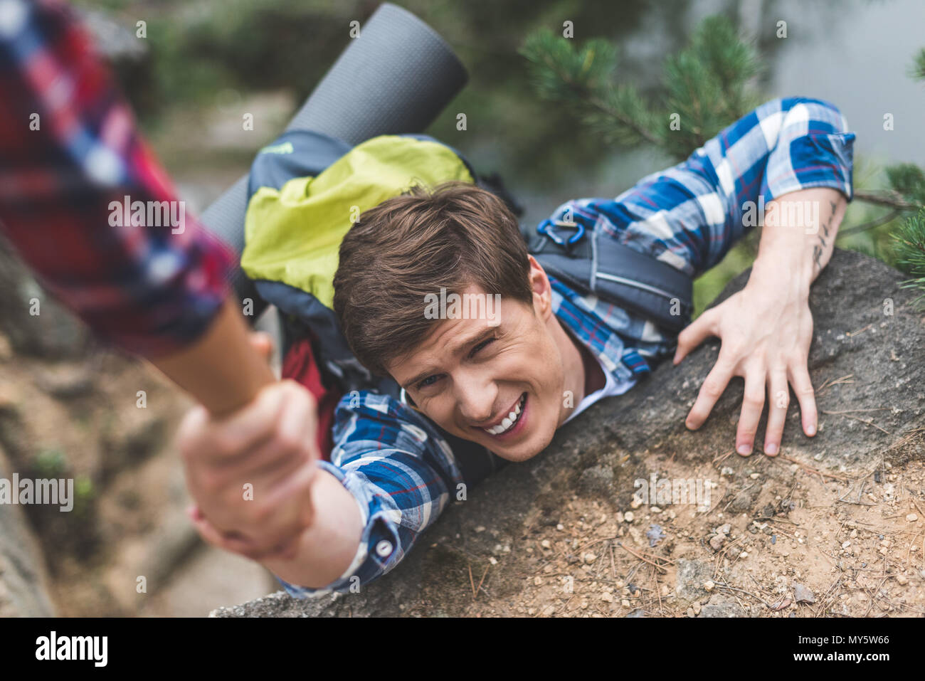 close-up shot of woman helping exhausted boyfriend to climb rock Stock ...
