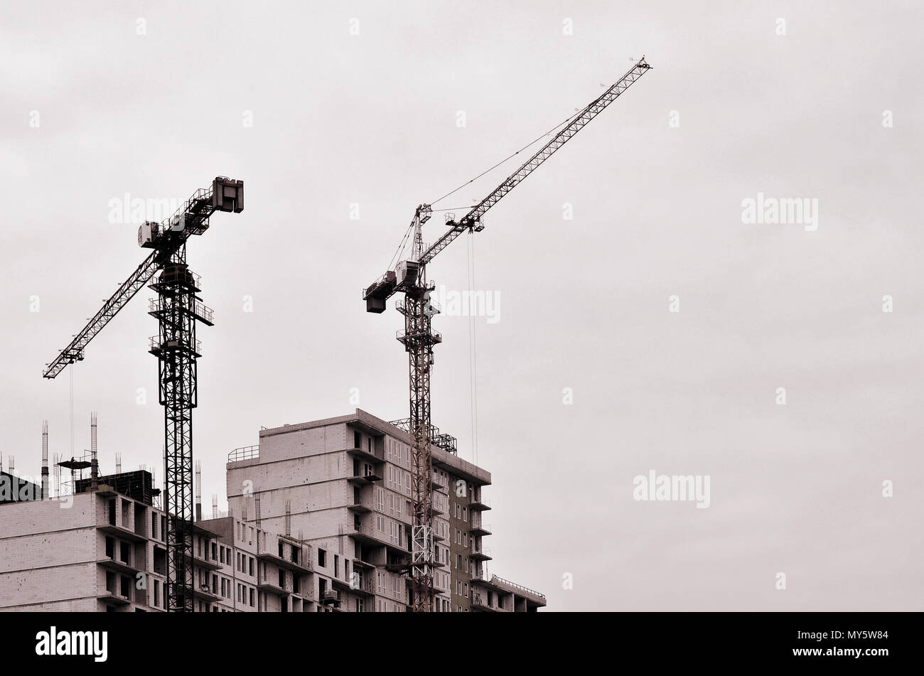 Working tall cranes inside place for with tall buildings under ...
