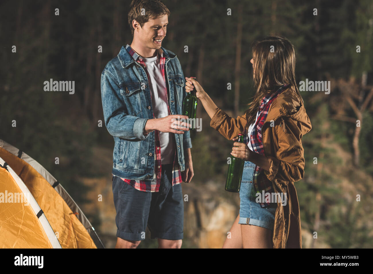 young couple sharing beer in hiking trip at night Stock Photo - Alamy