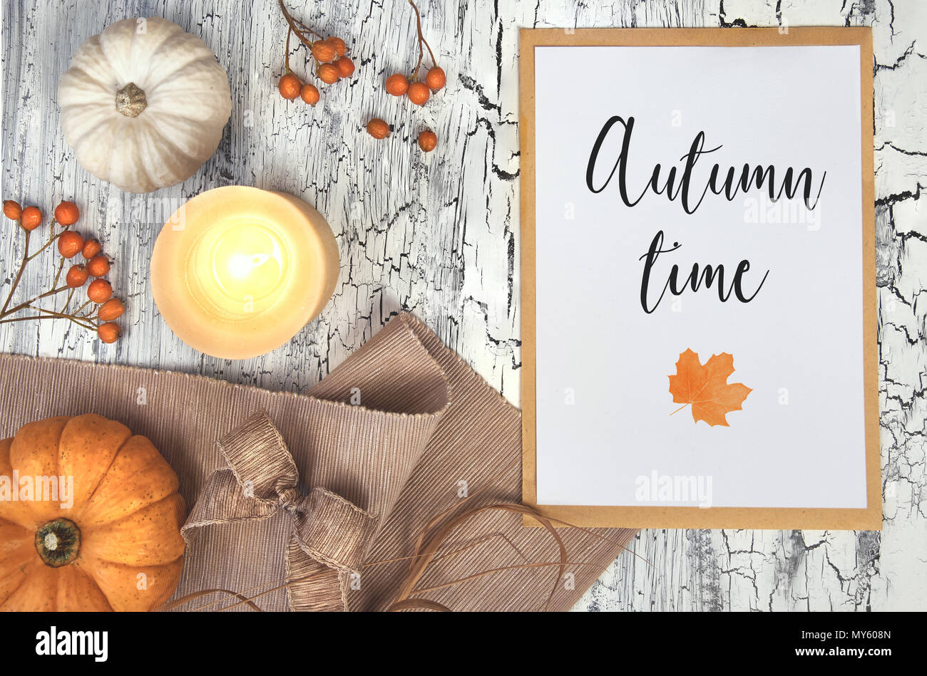 White block note with written text "Autumn time" and a marple leave on ...