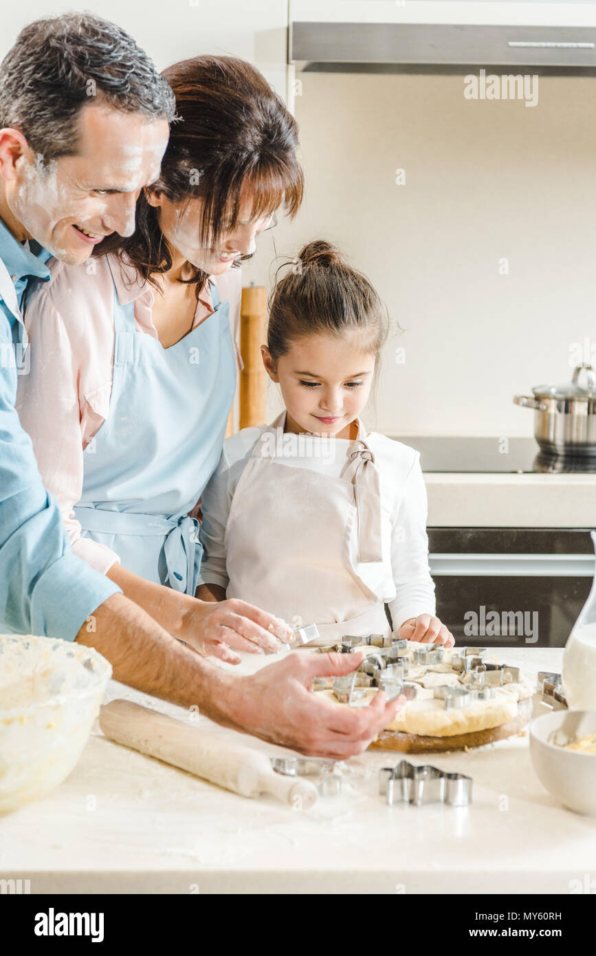happy caucasian family in flour making forms of dough at kitchen Stock ...
