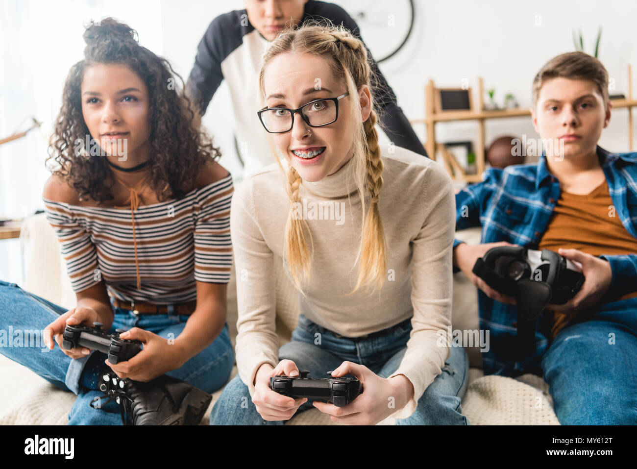 group of multiethnic teens playing video game at home Stock Photo - Alamy