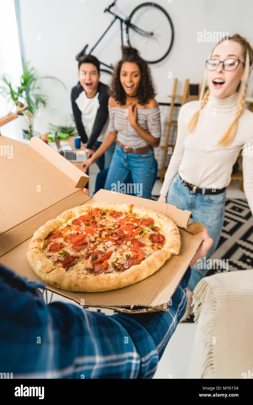 excited multicultural teens looking at pizza Stock Photo - Alamy