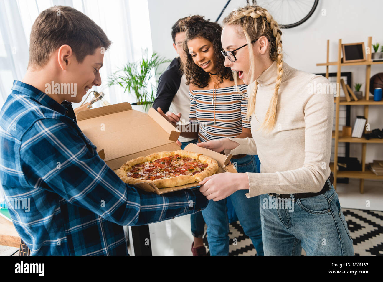 group of multicultural teens excited about pizza Stock Photo - Alamy