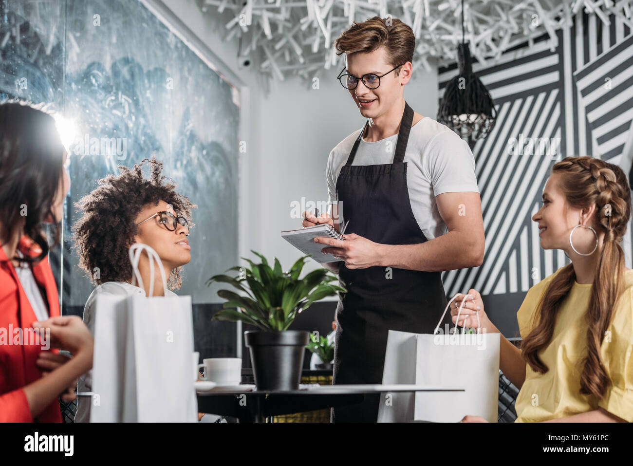 group of stylish multiethnic women making order in cafe Stock Photo - Alamy
