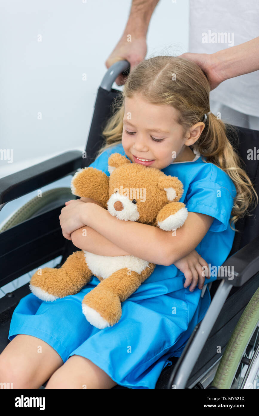 little child with teddy bear sitting in wheelchair in hospital Stock ...