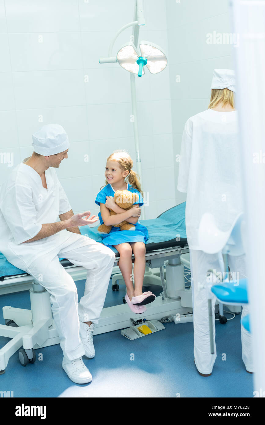 doctors preparing smiling kid for surgery in operating room Stock Photo ...