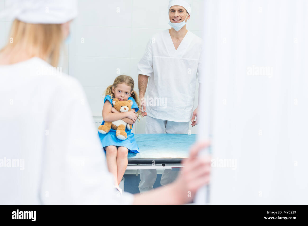 doctors preparing scared kid for surgery in operating room Stock Photo ...