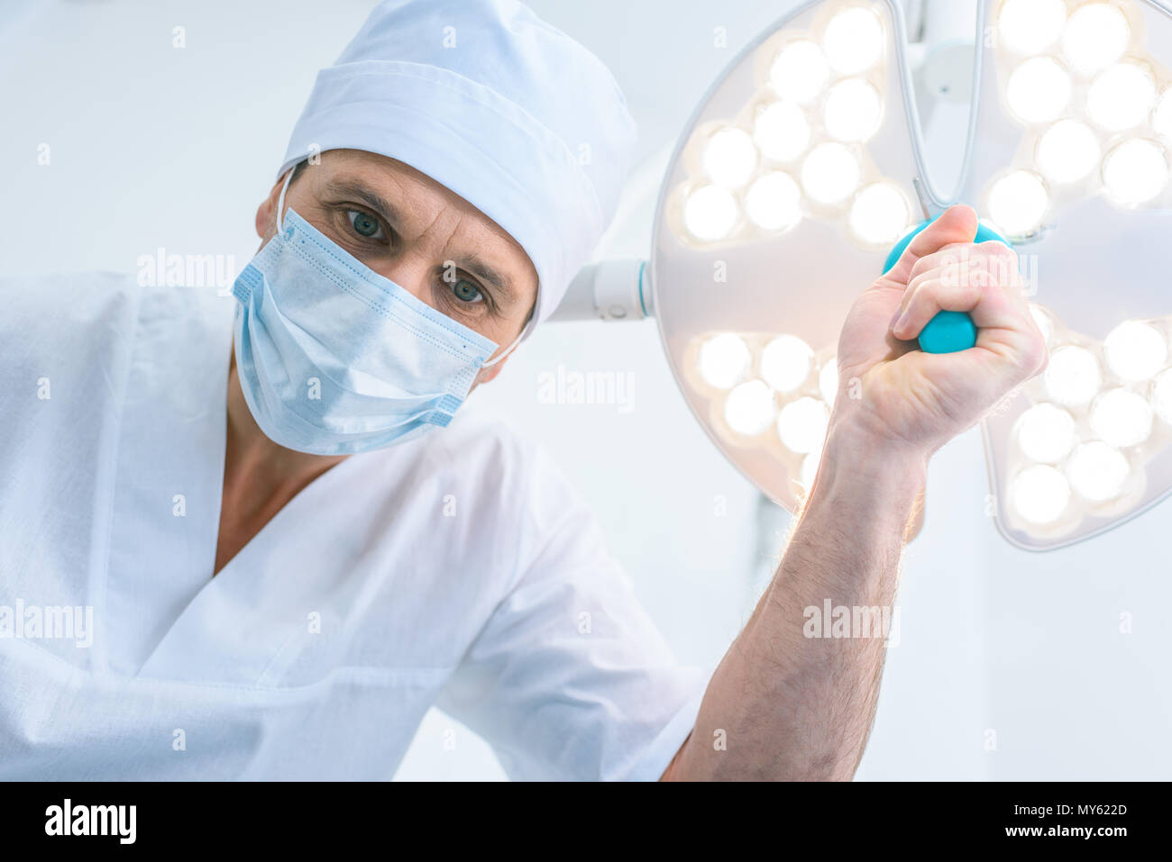 bottom view of doctor standing above patient in operating room and ...