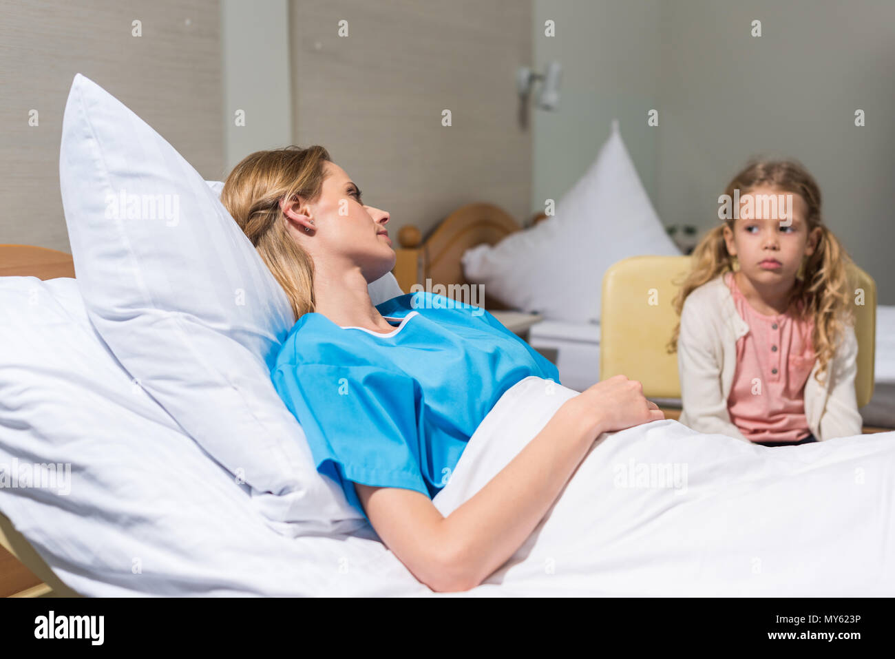upset daughter looking at sick mother at hospital Stock Photo - Alamy