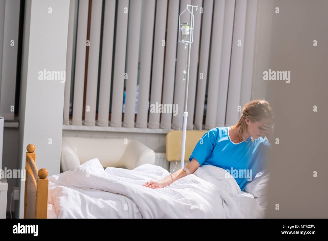 sick woman covering face with hand on hospital bed Stock Photo - Alamy