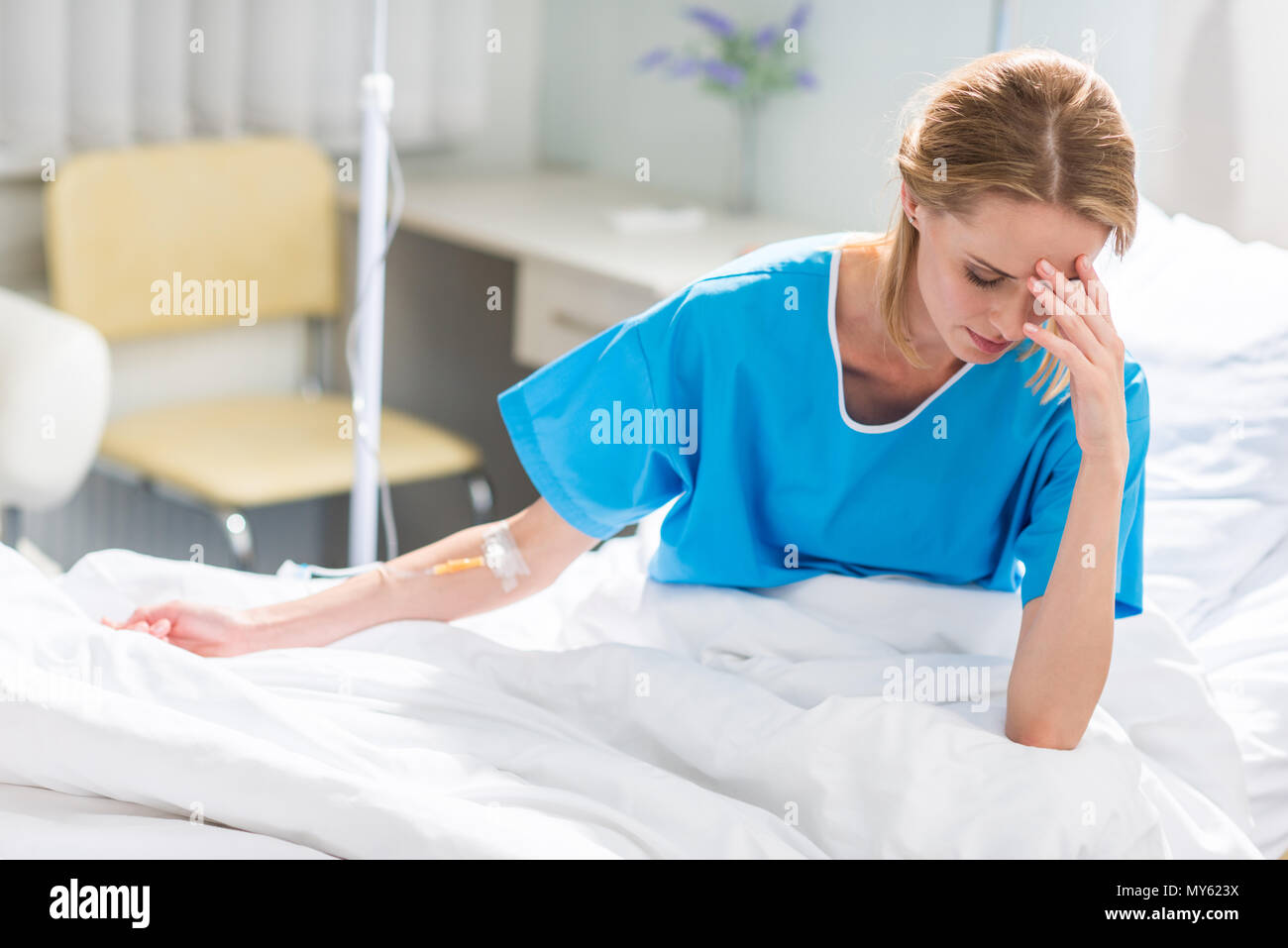 sick woman covering face with hand on hospital bed Stock Photo - Alamy