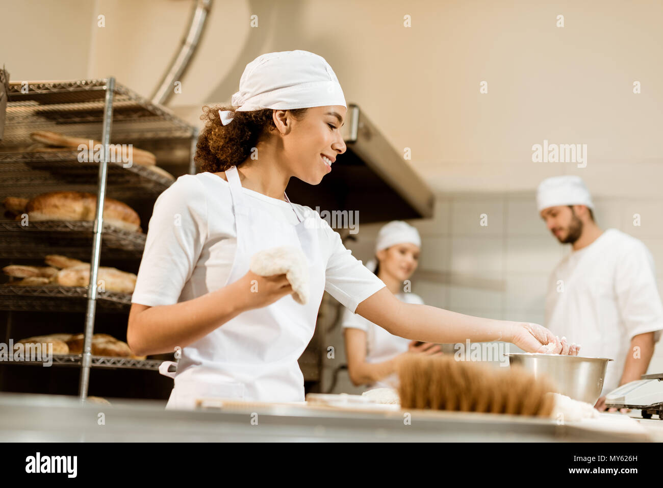 multiethnic team of bakers working together at baking manufacture Stock ...