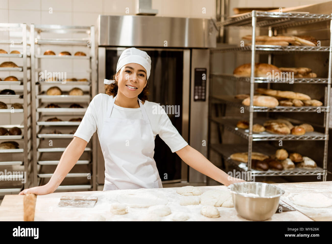 female baker standing at workplace on baking manufacture Stock Photo ...