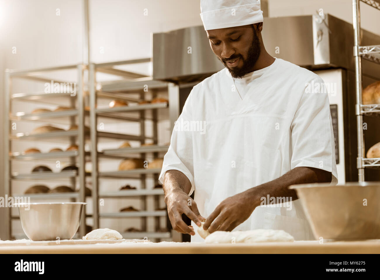 handsome african american baker preparing dough on baking manufacture ...