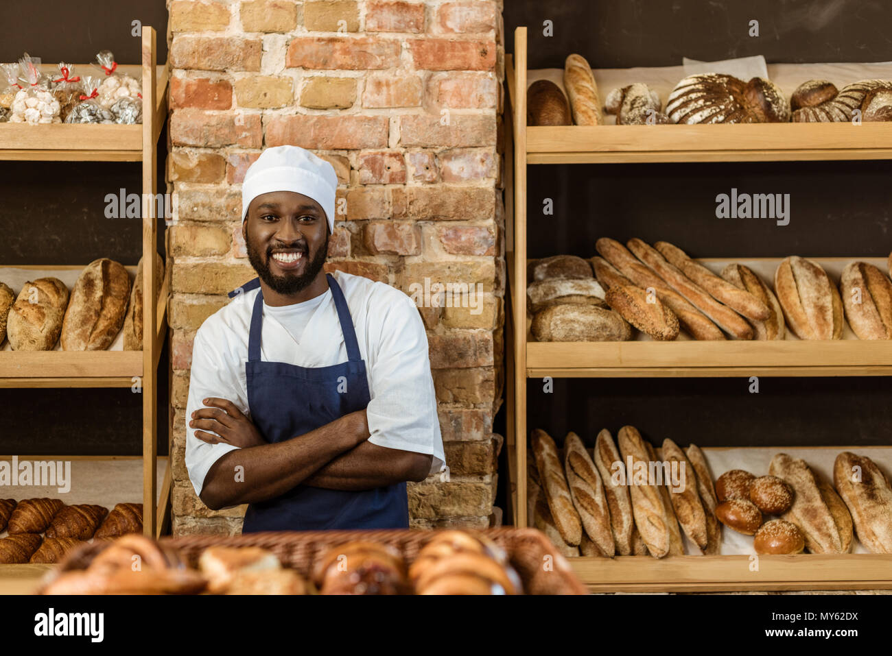 handsome smiling baker with folded arms standing at pastry store Stock ...