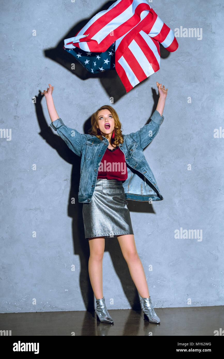 excited woman throwing american flag against concrete wall Stock Photo ...