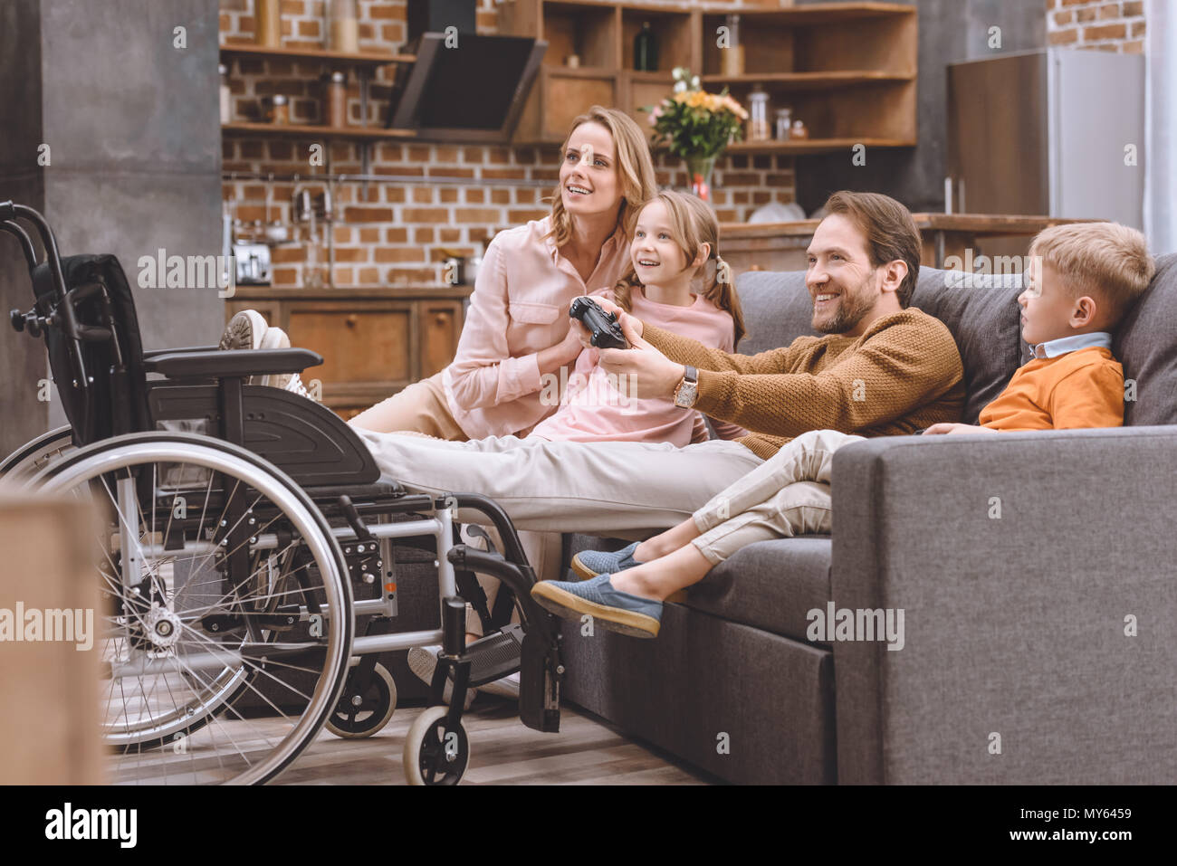 happy family with disabled father playing with joystick at home Stock ...