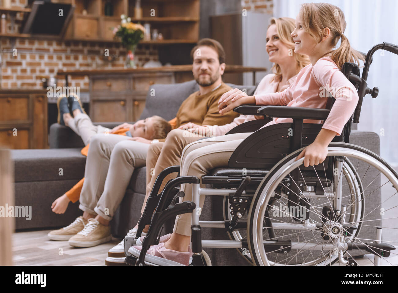 happy family with disabled little daughter in wheelchair spending time ...